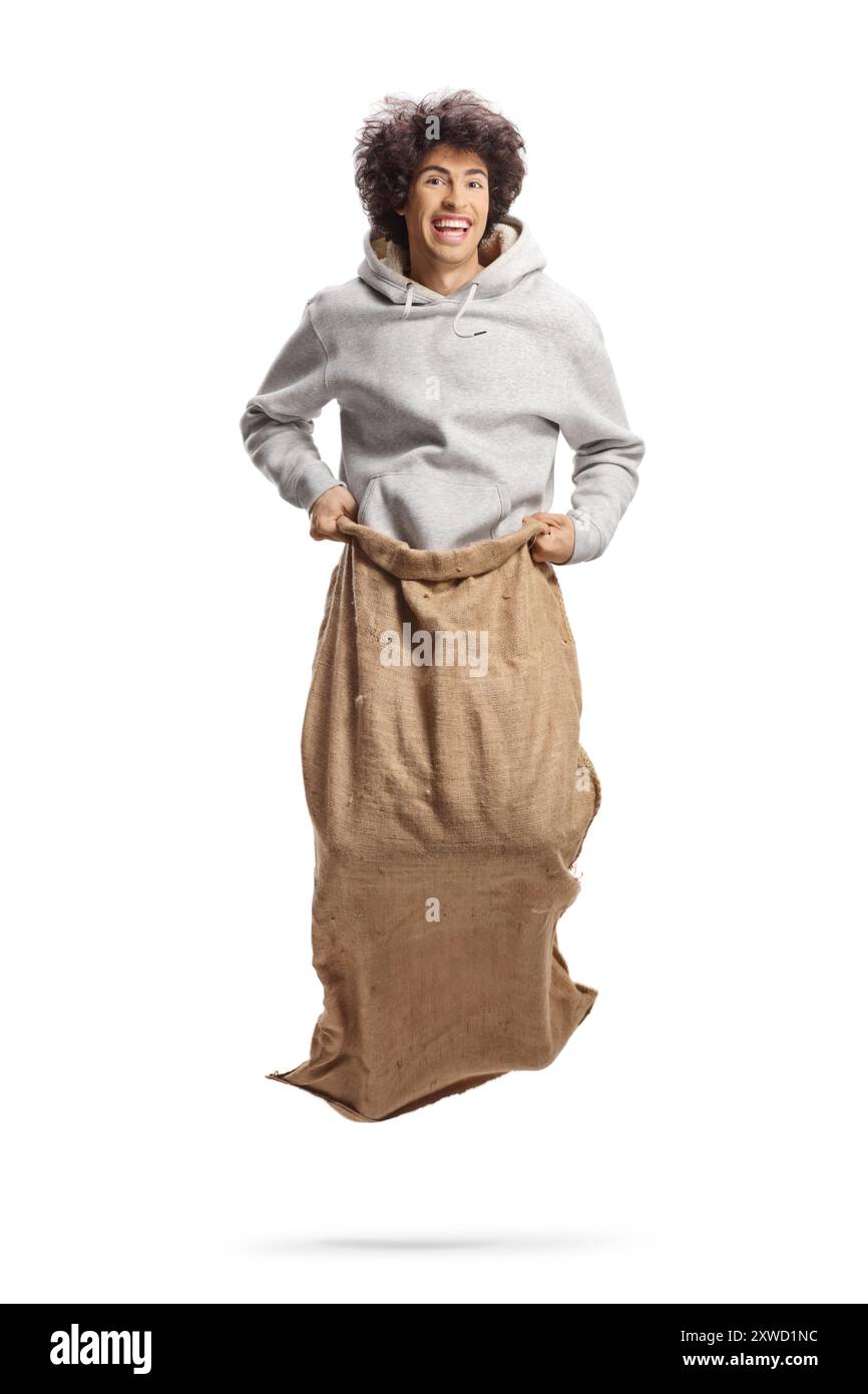 Full length portrait of a young man jumping in a sack and playing gunny ...