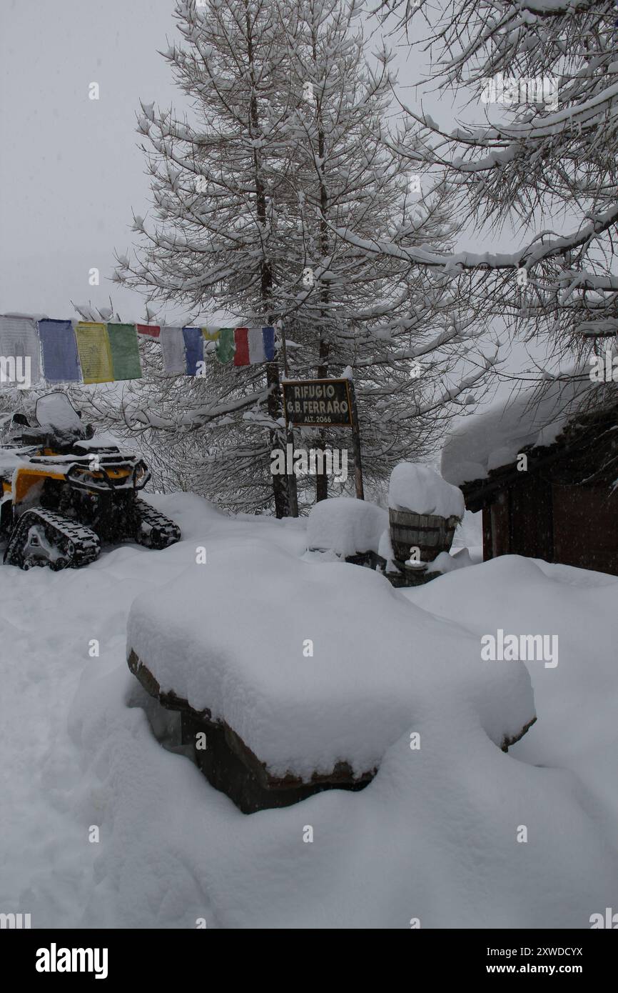 Snow covered terrain vehicle and furniture at Italian mountain rifugio ...