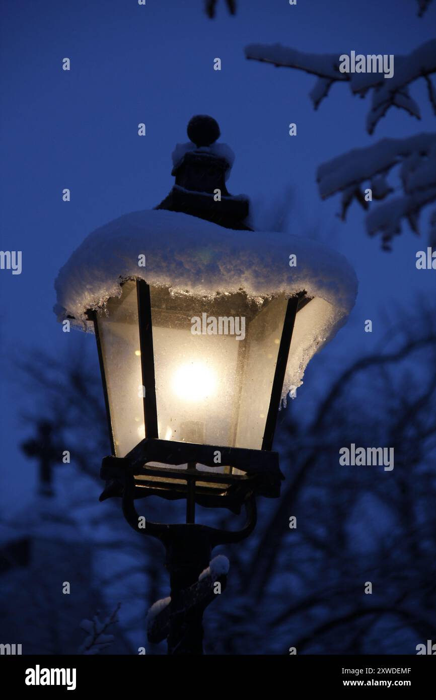 Snow covered street lamp glowing in the dark winter night Stock Photo ...