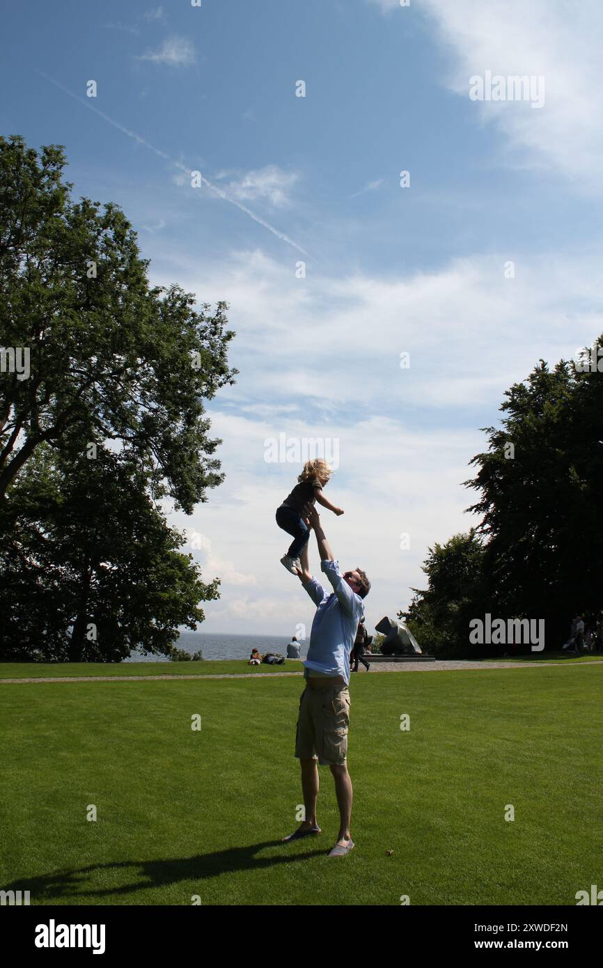 Father raising his daughter into the sky at Louisiana Art Museum in ...