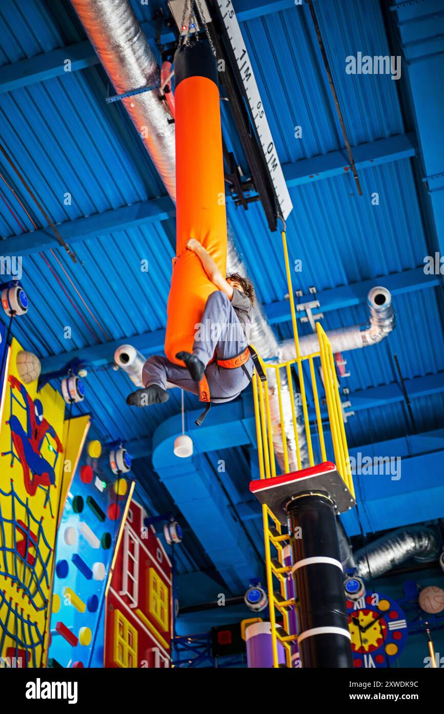 happy boy with a harness training in the rock climbing room. Family ...