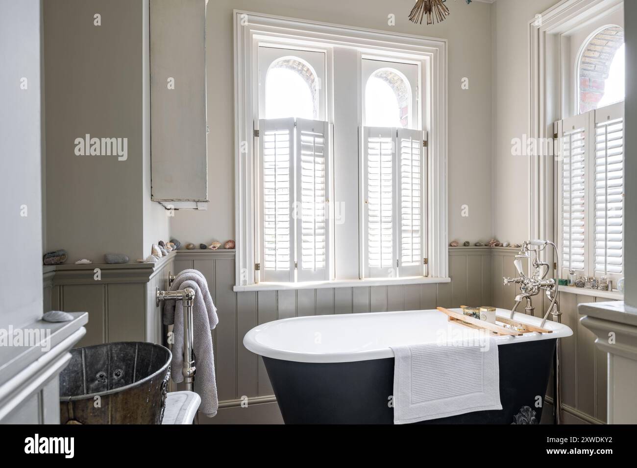 Freestanding roll-top bath in windows with shutters. Wimbledon home ...