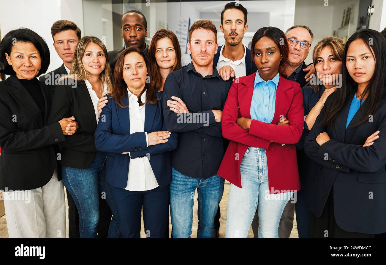 Multigenerational workers smiling in front of camera inside business ...