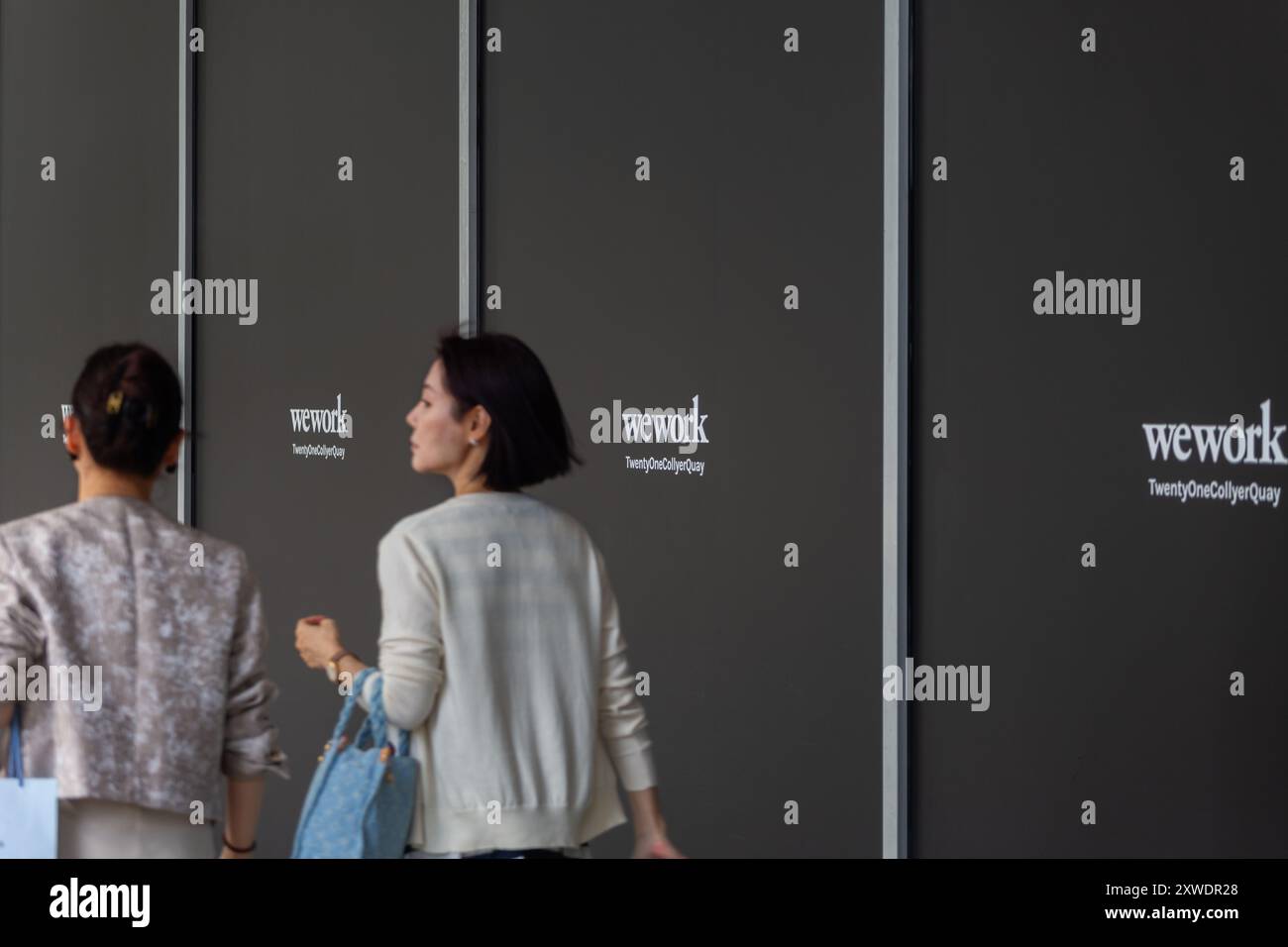 19 Aug 2024. Two Chinese corporate asian woman walk past Wework Twenty ...