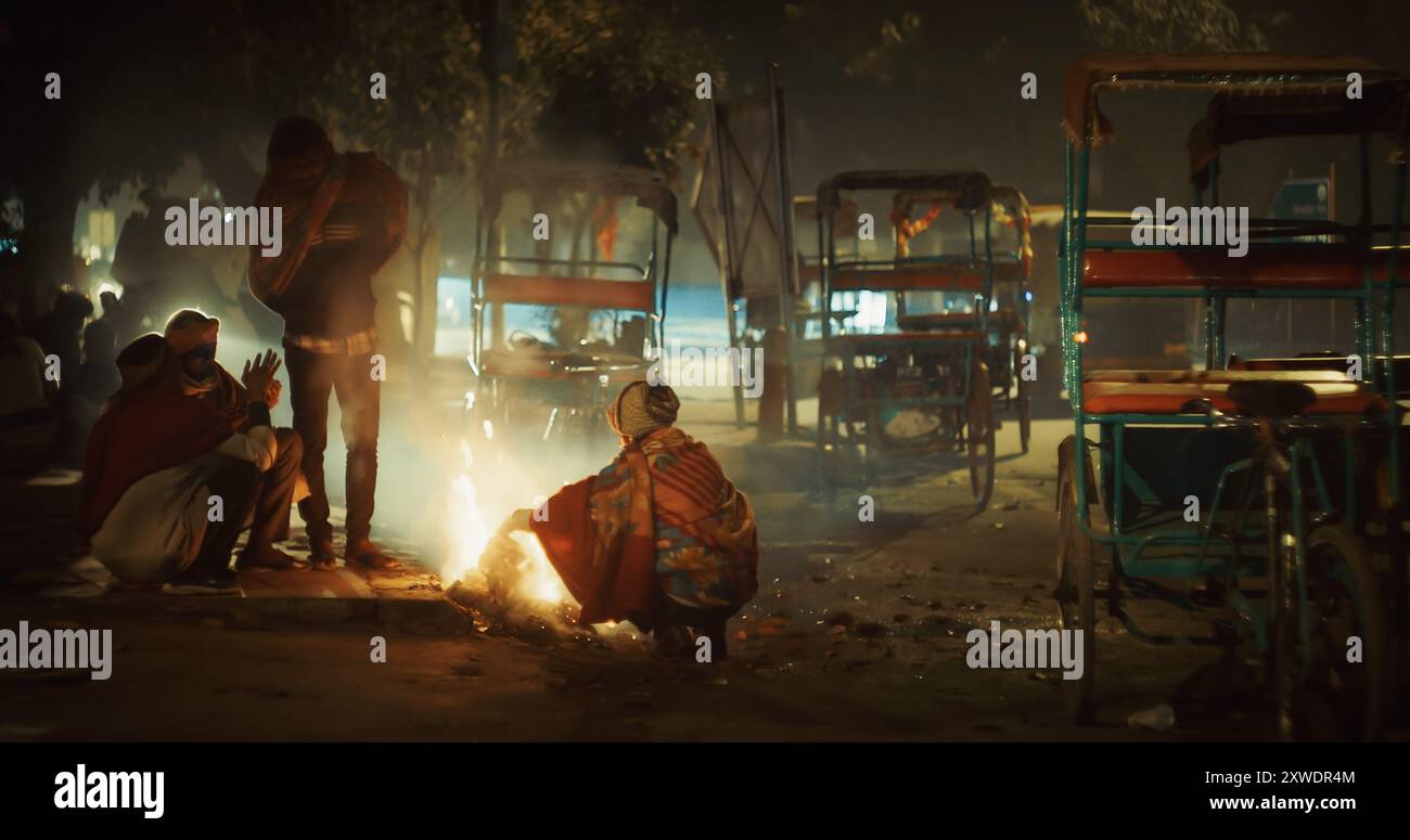 New Delhi, Delhi, India. Tuk tuk Drivers light a fire on the sidewalk ...