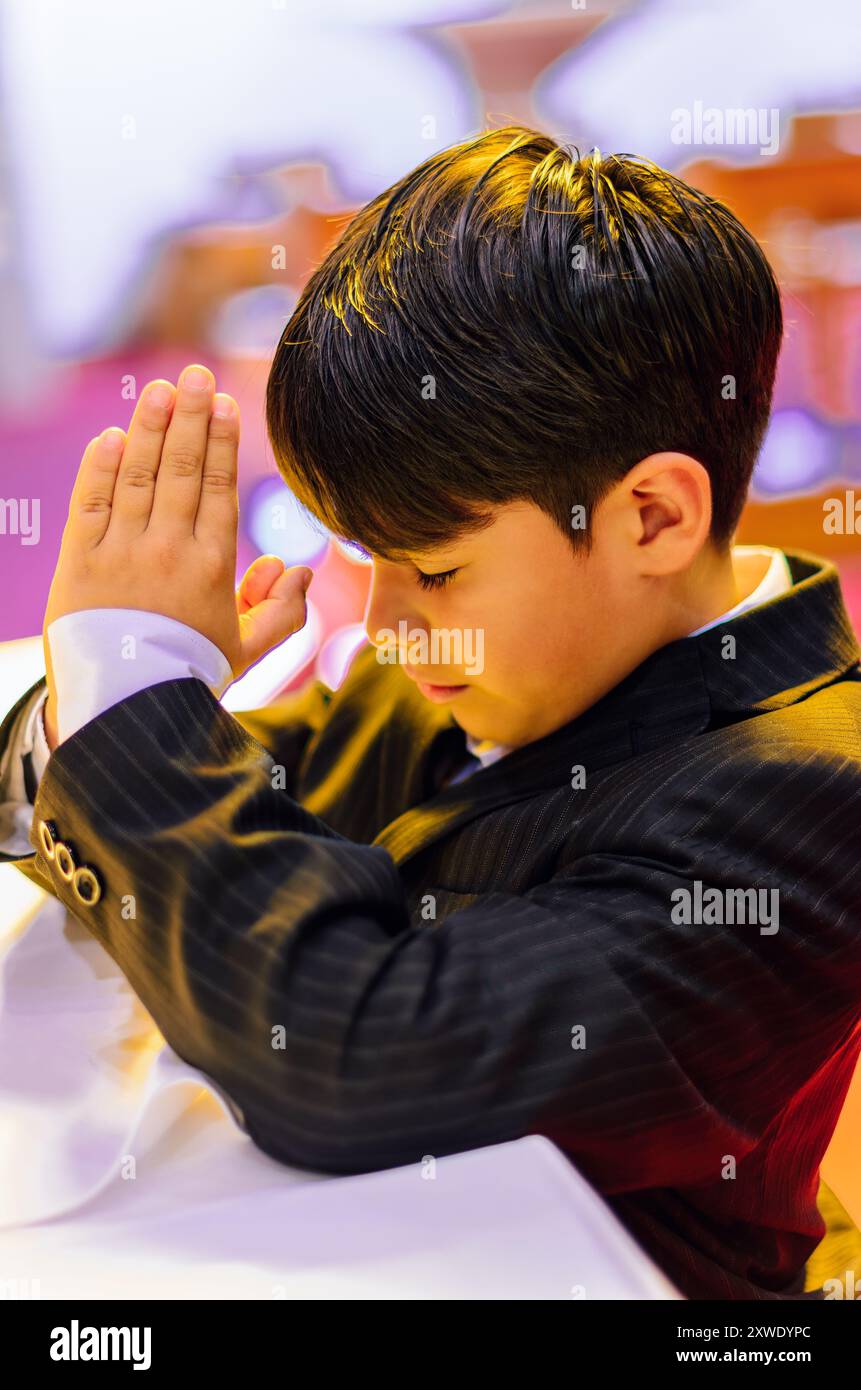 Child boy of Latin American descent praying in Catholic church Stock ...