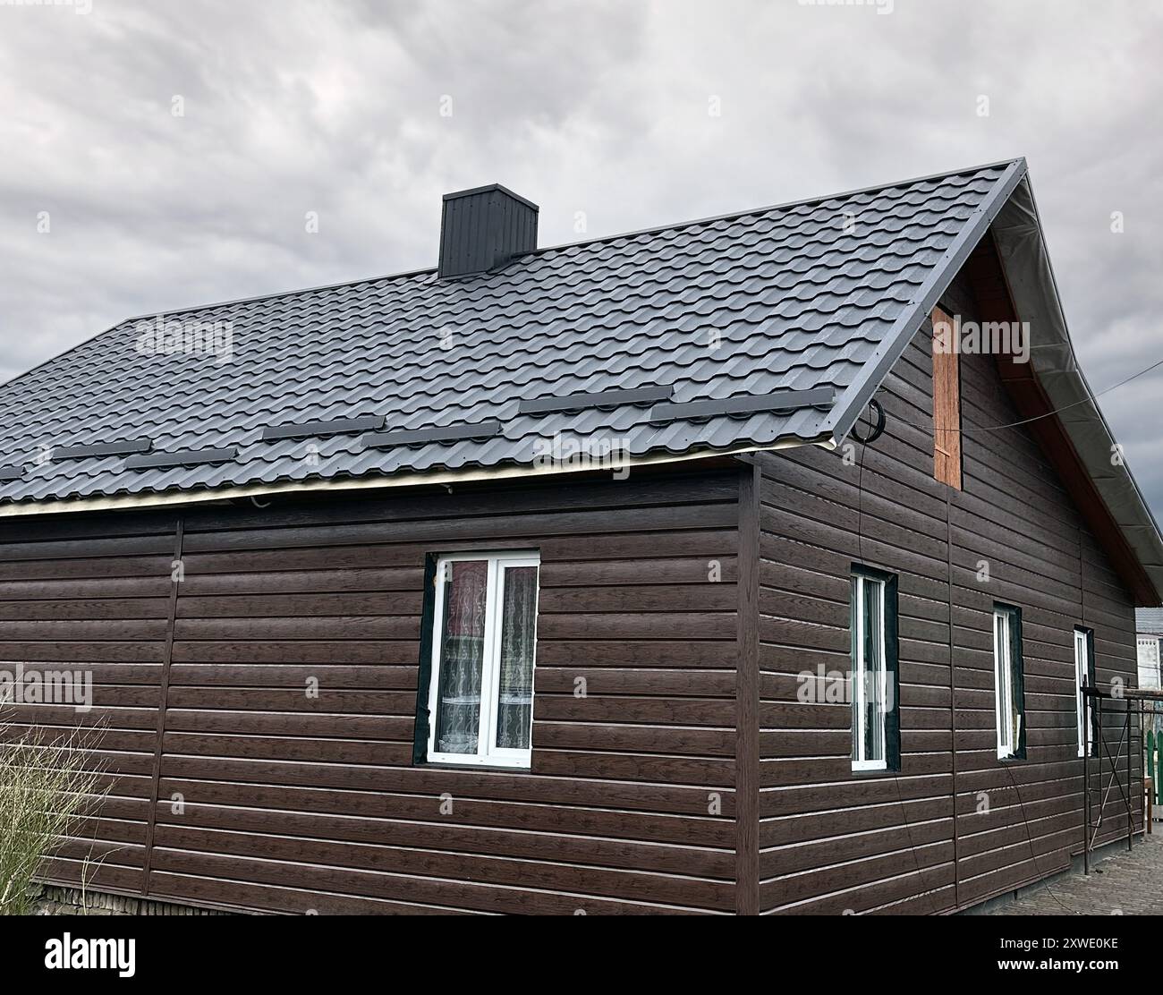 Close-up house roof with steel roofing sheet. Dark modular tile effect ...