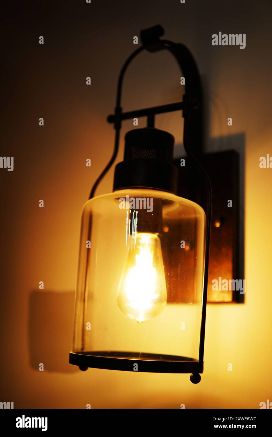 Old industrial lantern lamp on the living room wall. Aged black metal ...