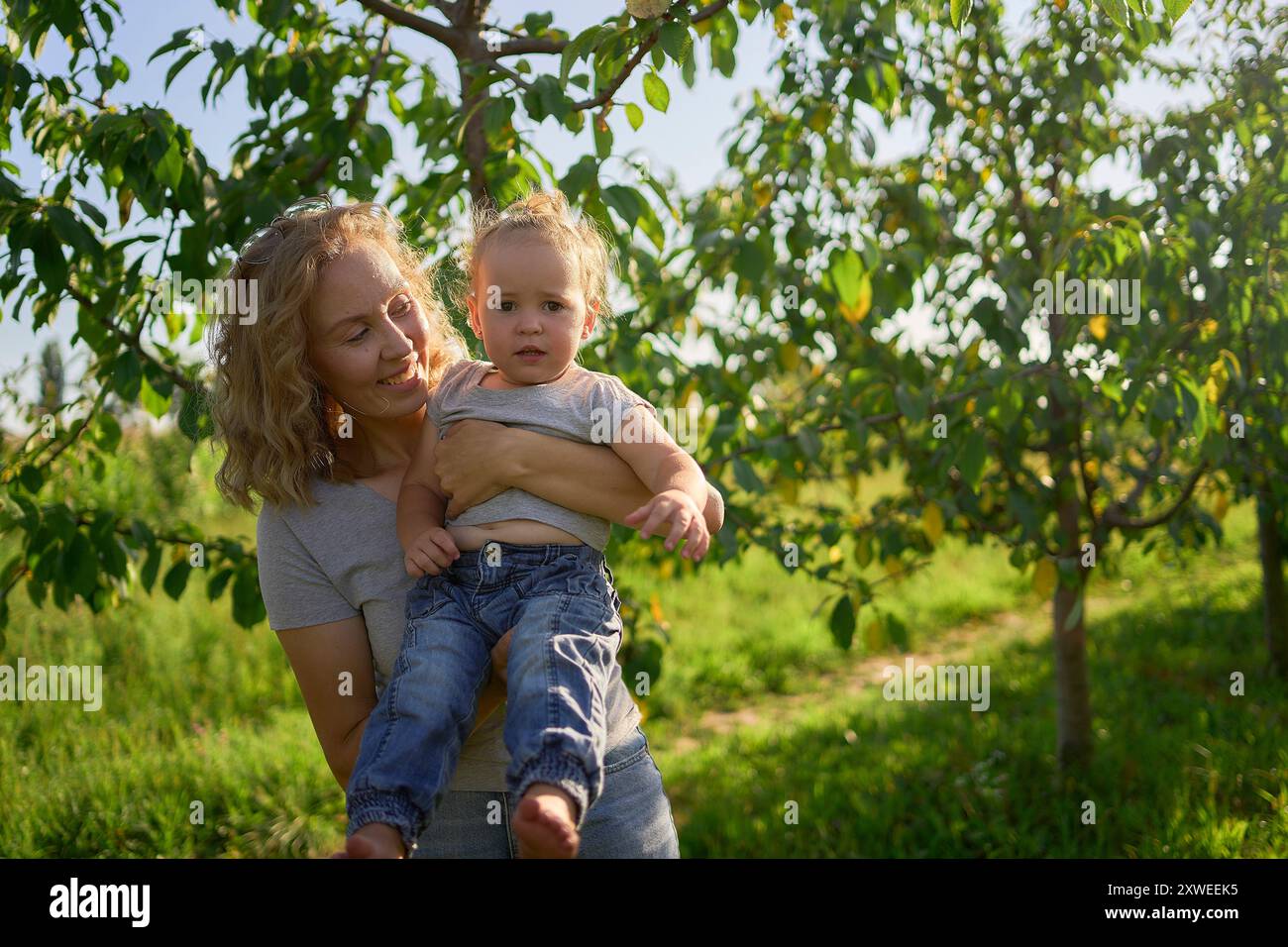 family of four is playing catch bubbles in the garden Stock Photo - Alamy