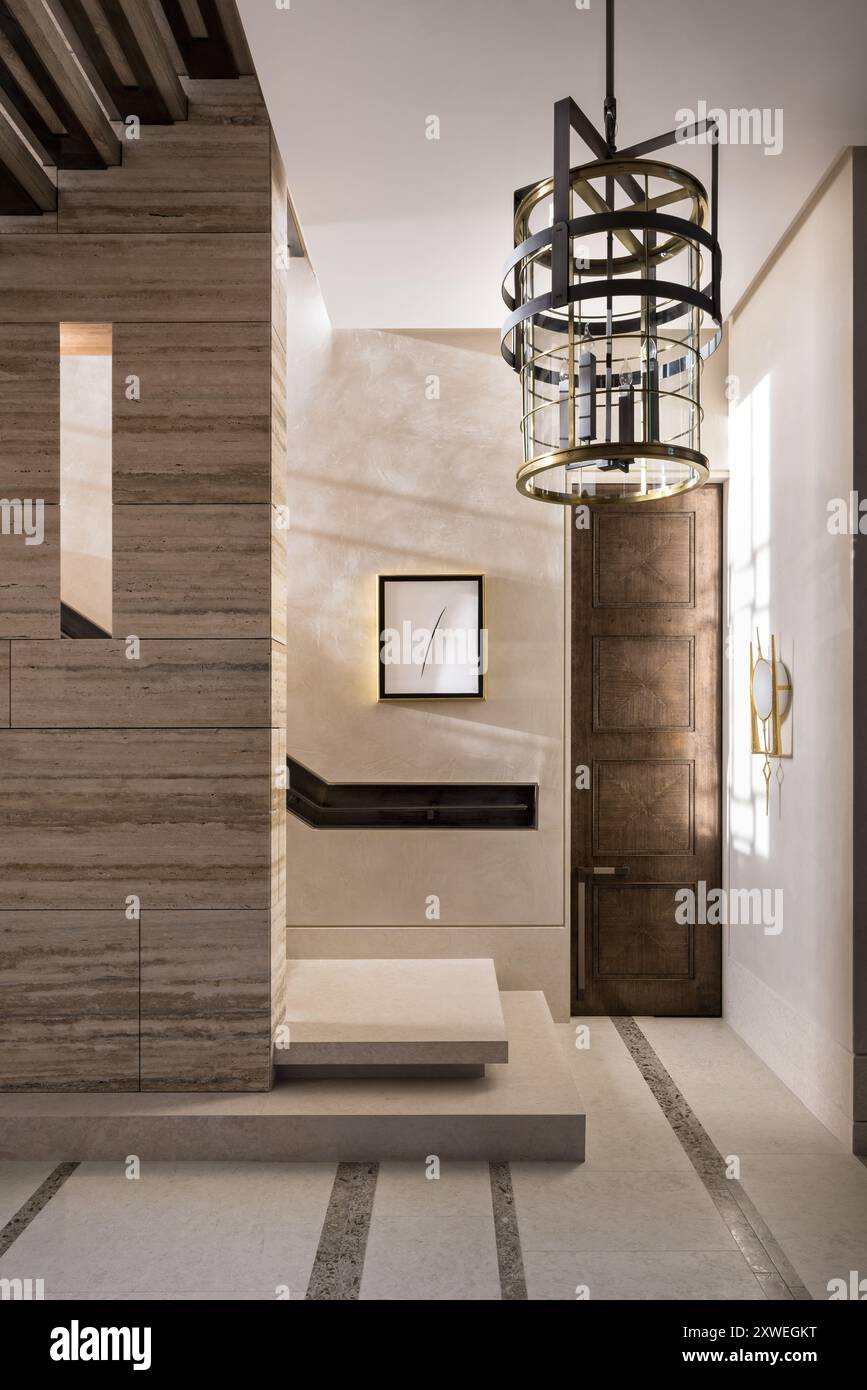 Designer lighting in travertine hallway of luxury modern British home ...