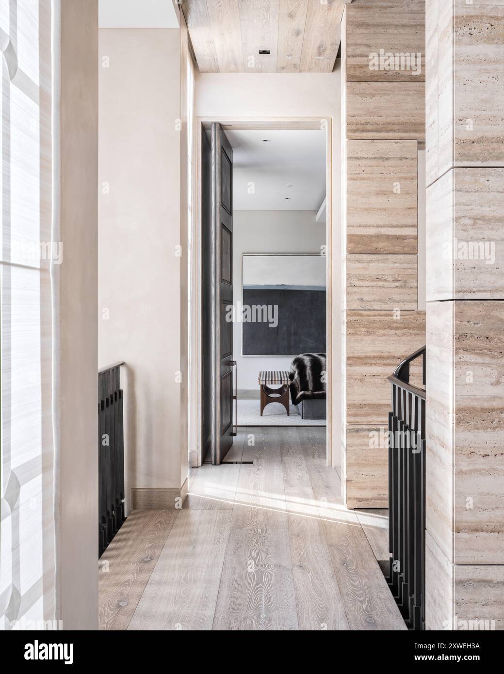 View through open doorway from travertine hallway in luxury modern ...