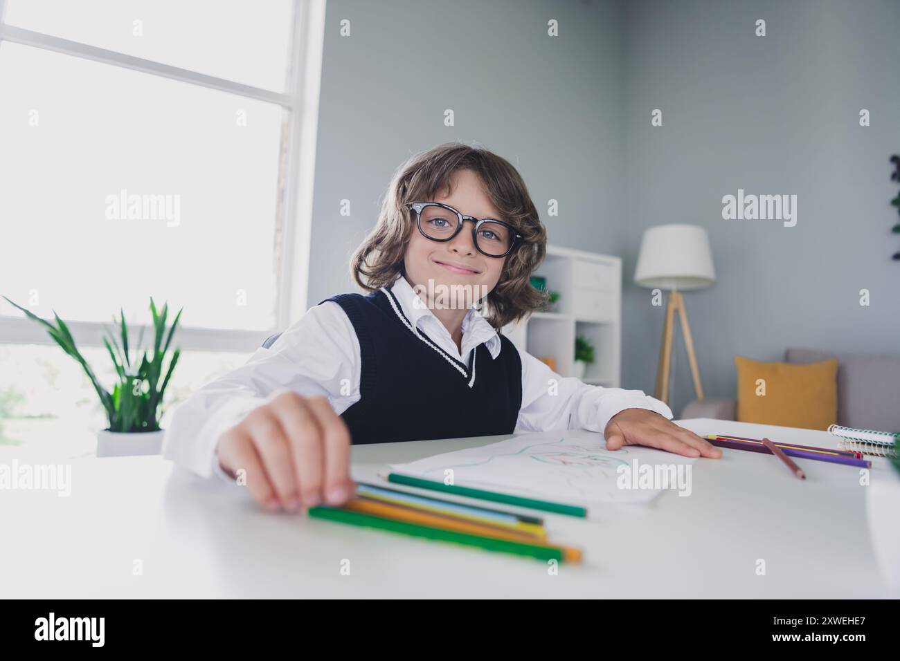 Portrait of diligent adorable schoolkid hold pencil drawing notebook ...