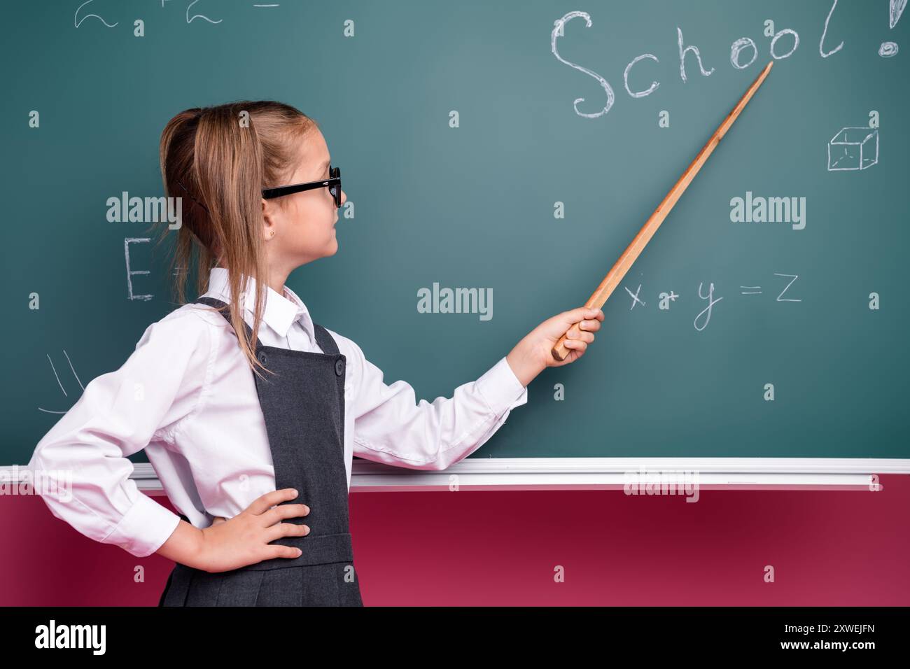 Photo of cute little schoolgirl diligent hold pointer stick teaching ...