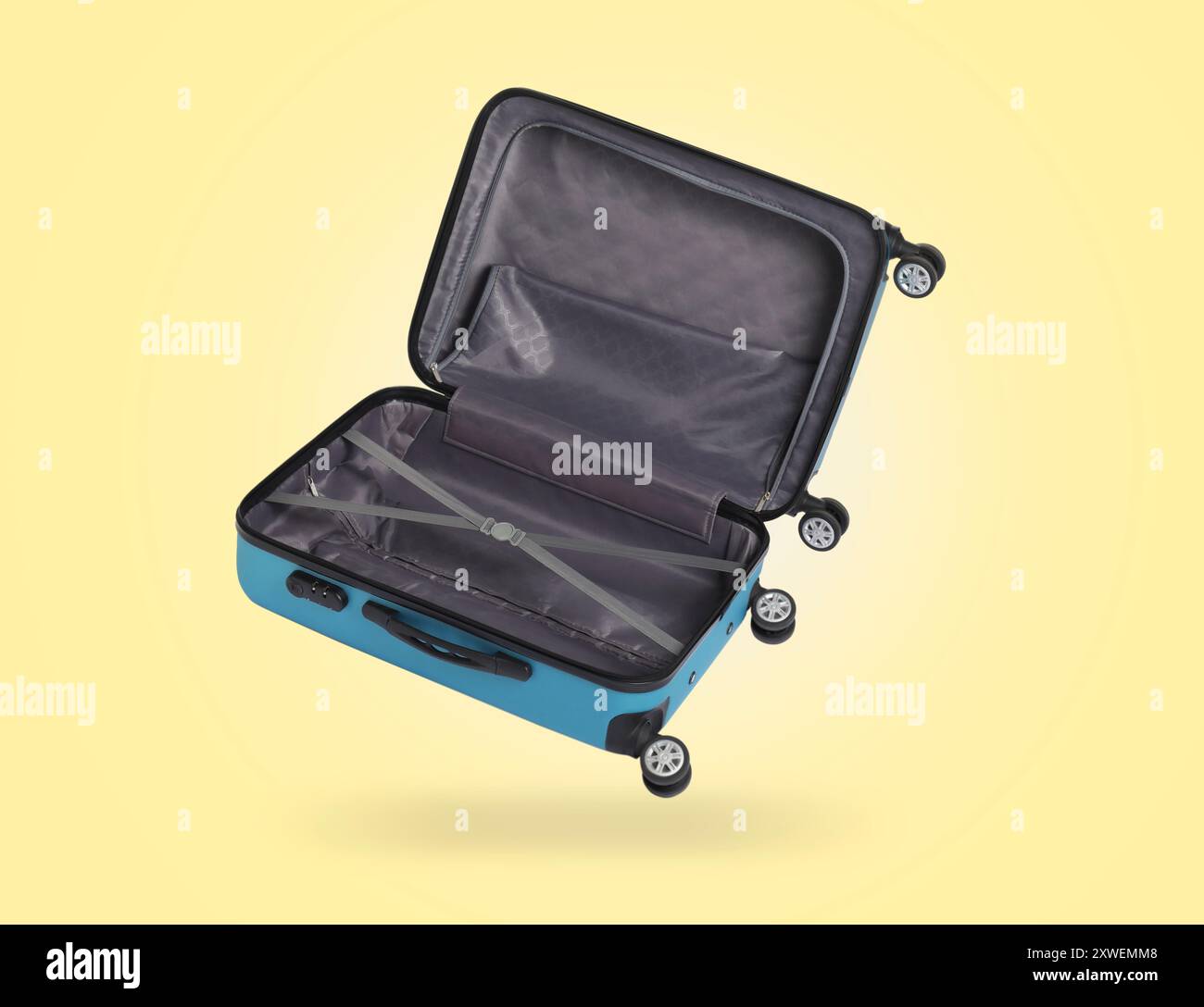 Open empty suitcase in air on pale yellow background Stock Photo - Alamy