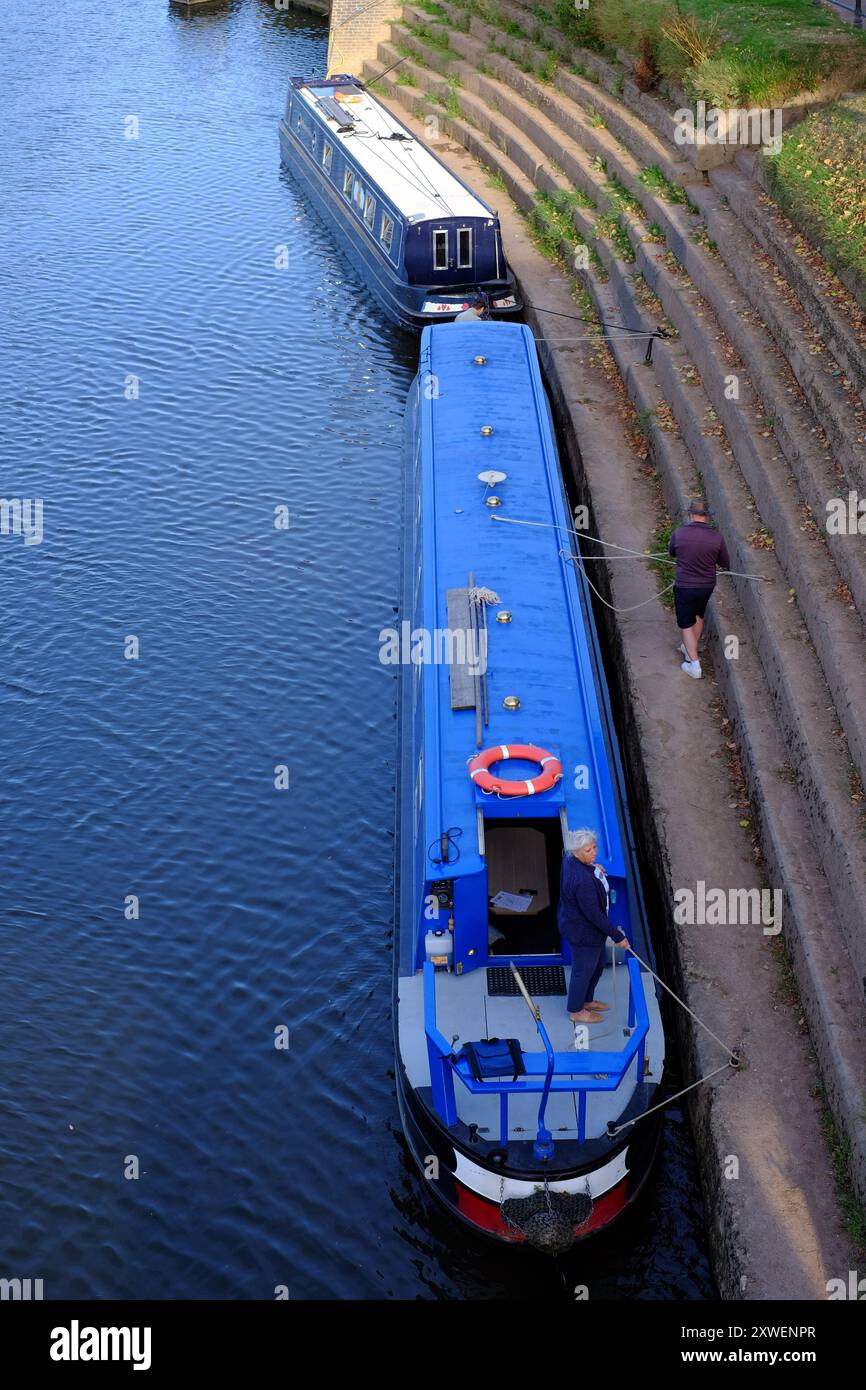 Couple mooring narrowboat to riverside on the River Severn at Upton ...