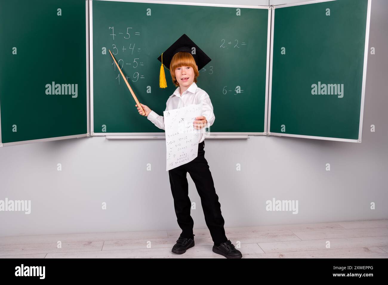 Full length photo of small schoolboy graduation hat teacher hold ...