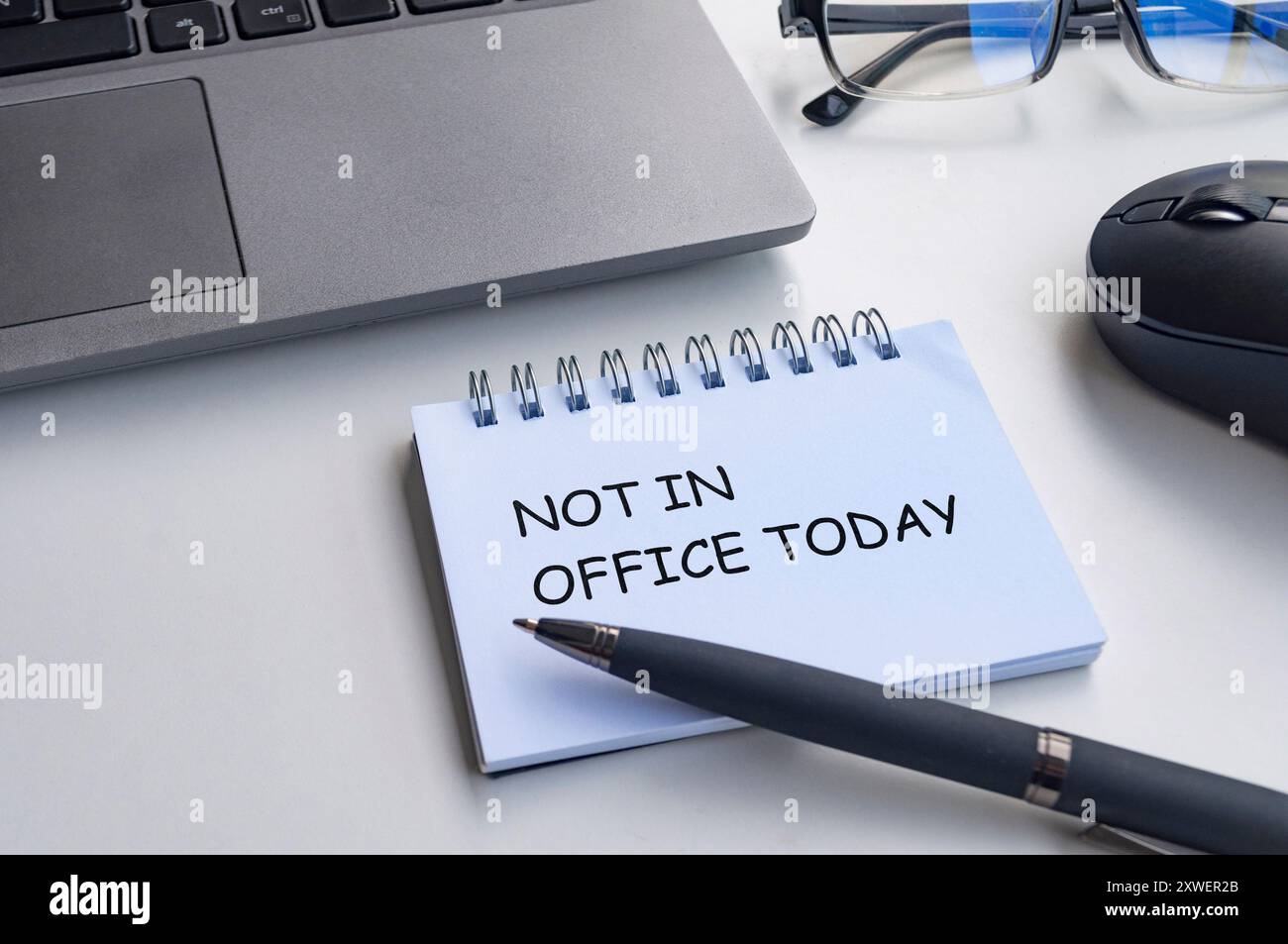 Not in office today text on with notepad with office background. Out of ...