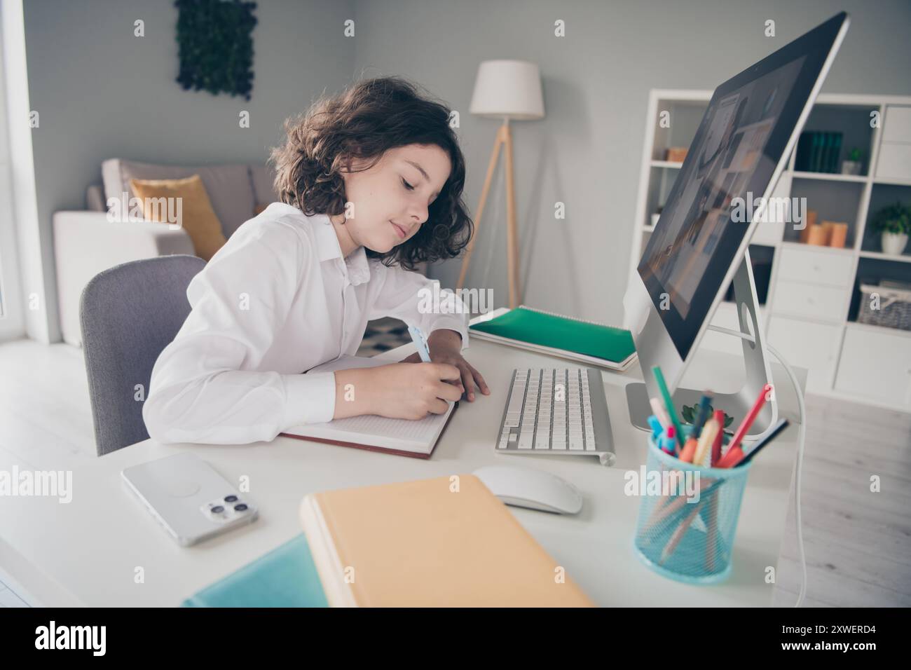 Photo of charming concentrated little boy schoolkid wearing white shirt ...