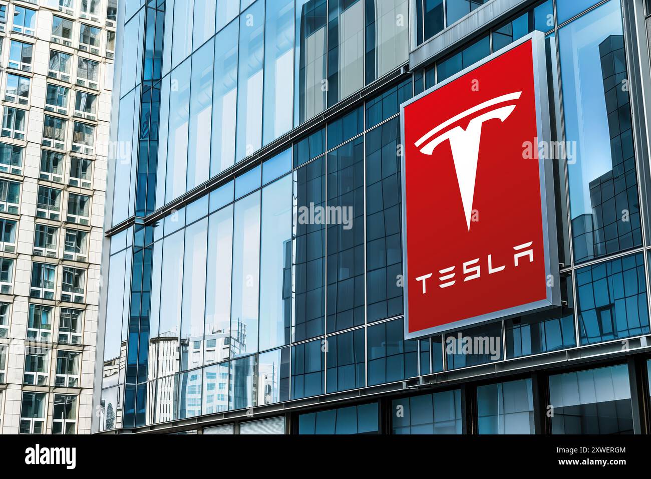 Illuminated banner with Tesla car manufacturer's logo on a glass office ...