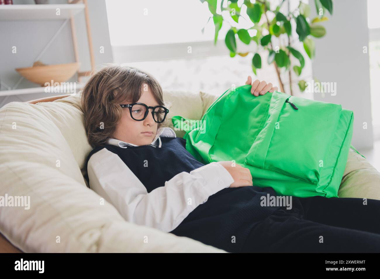 Portrait of tired sad cute clever intelligent boy relax rest home after ...