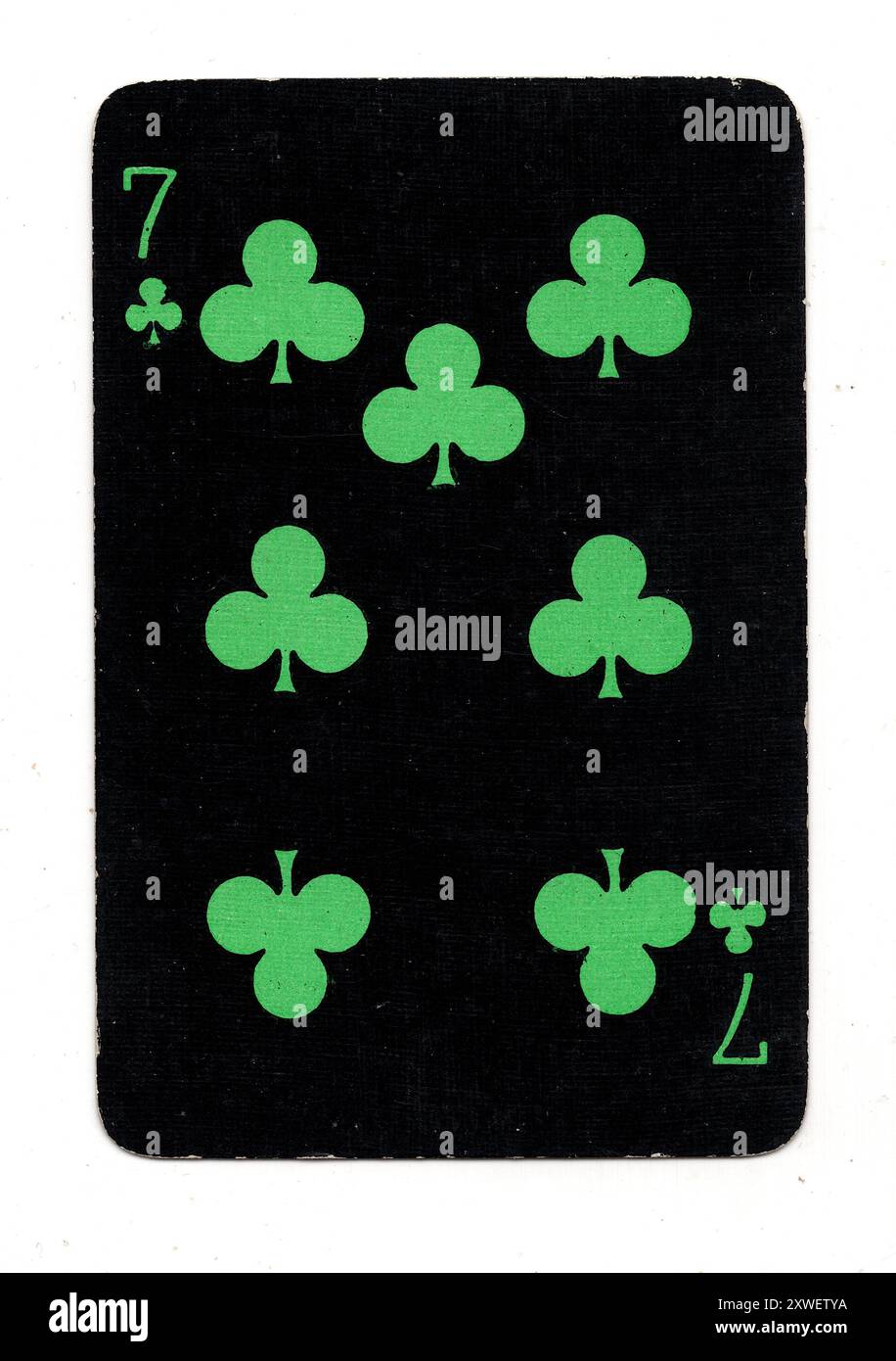 A vintage black seven of clubs playing card isolated on a white ...