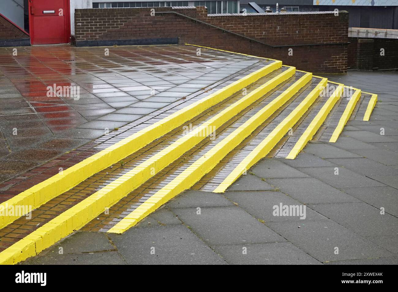 Level pavement outside car park abuts down hill walkway towards ...
