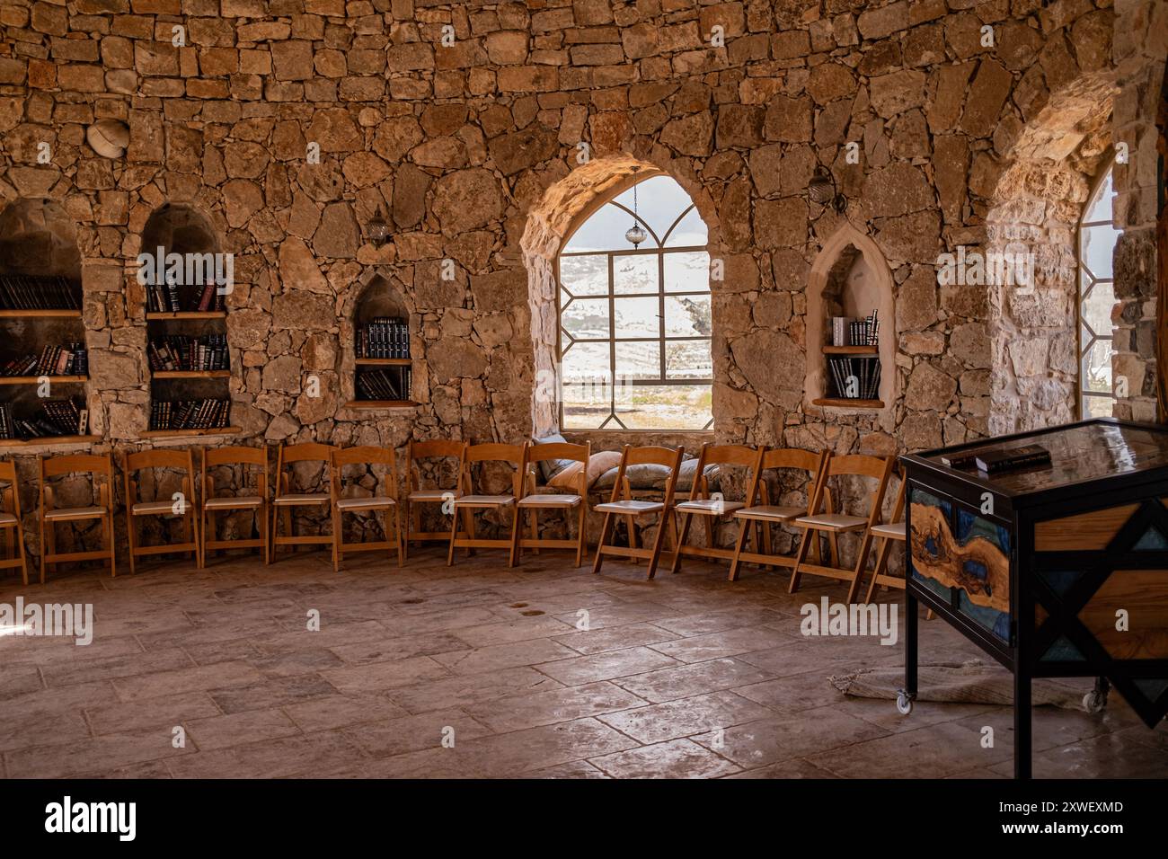 The rustic interior of an ancient-looking synagogue with stone walls in ...