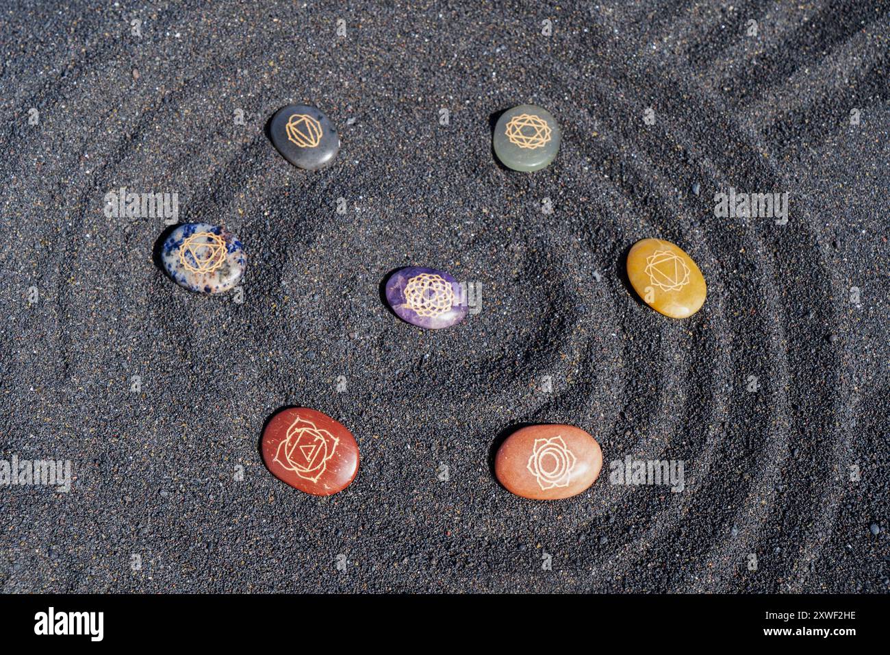 Healing crystals on black sand background Stock Photo - Alamy