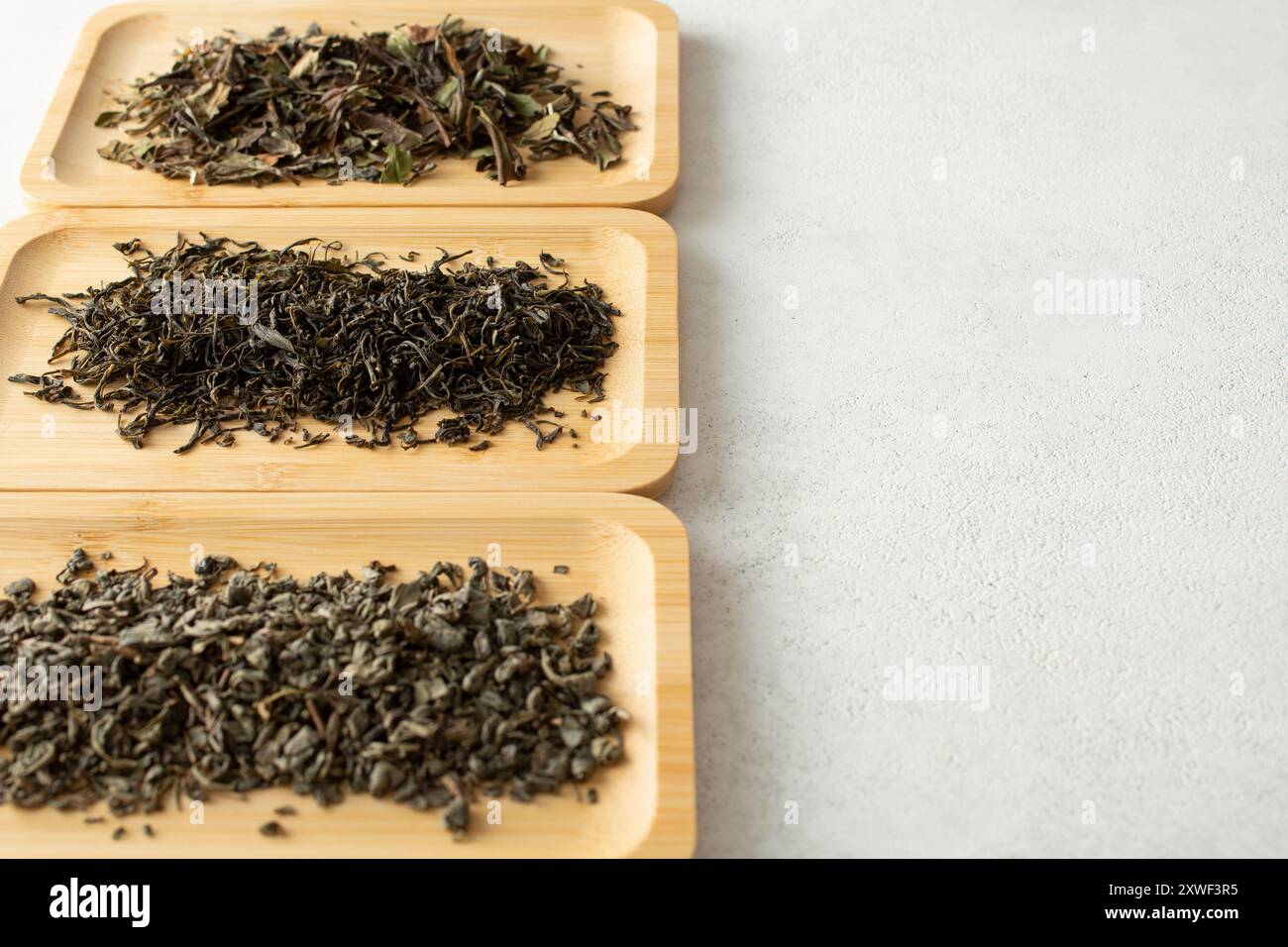 A view of assorted loose leaf tea on bamboo trays, on the left side of ...