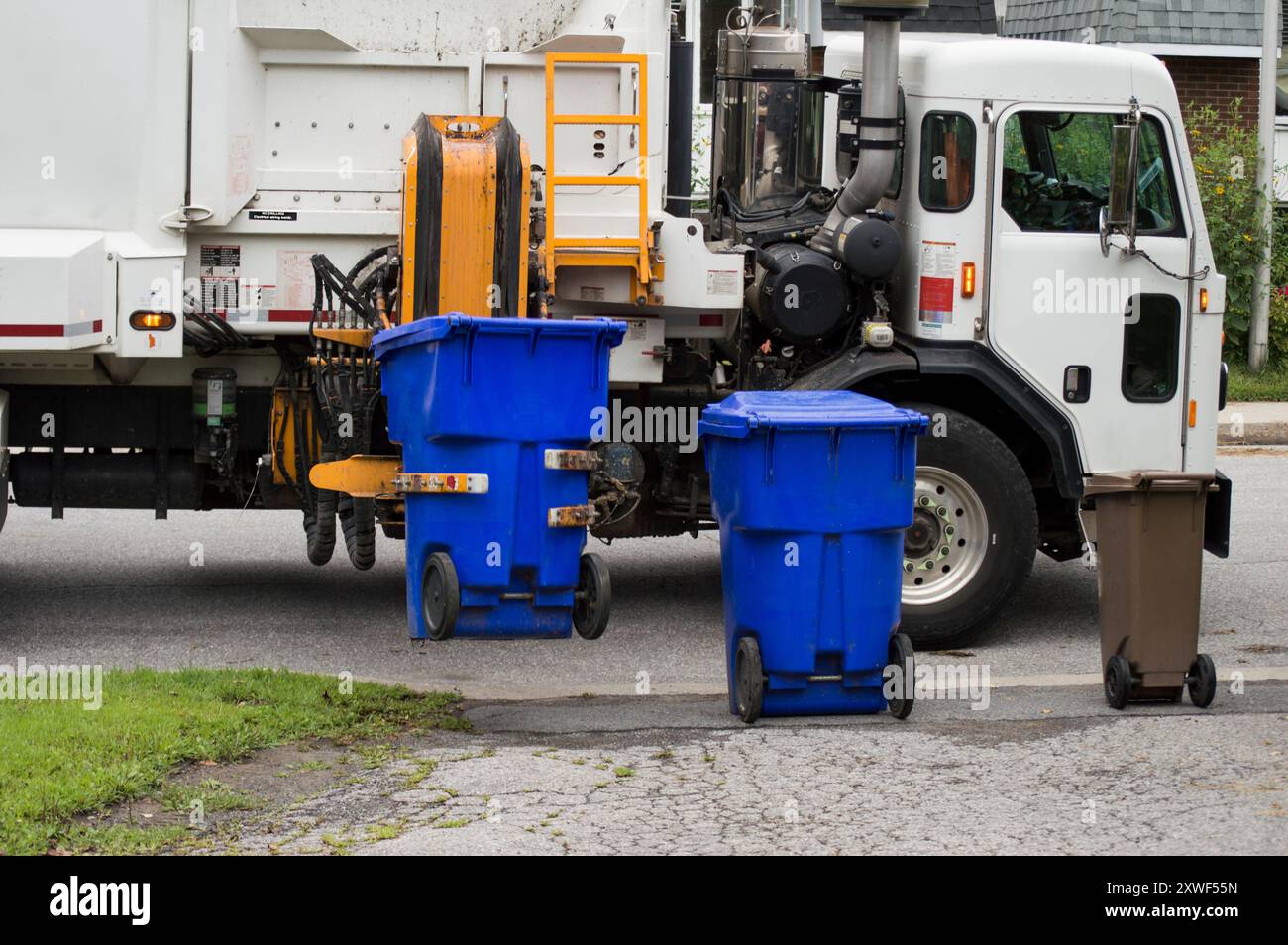 Robotic arm garbage truck, picks up recycling from the side of the road ...