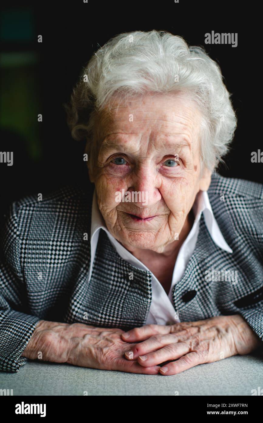 A portrait of an elderly woman with kind eyes and a positive expression ...