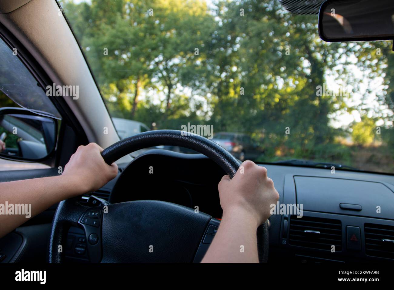 Happy teen girl sitting on driver seat in new car joyful smiling hold ...