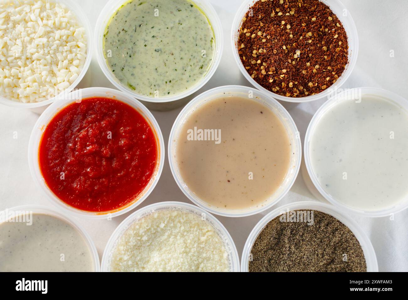 A top down view of a variety of sauce and condiments in large plastic ...