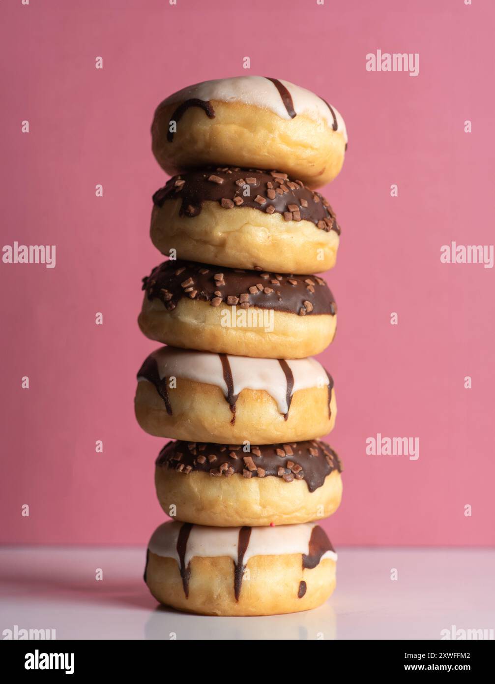 Vertical stack of six delectable donuts featuring chocolate and white ...