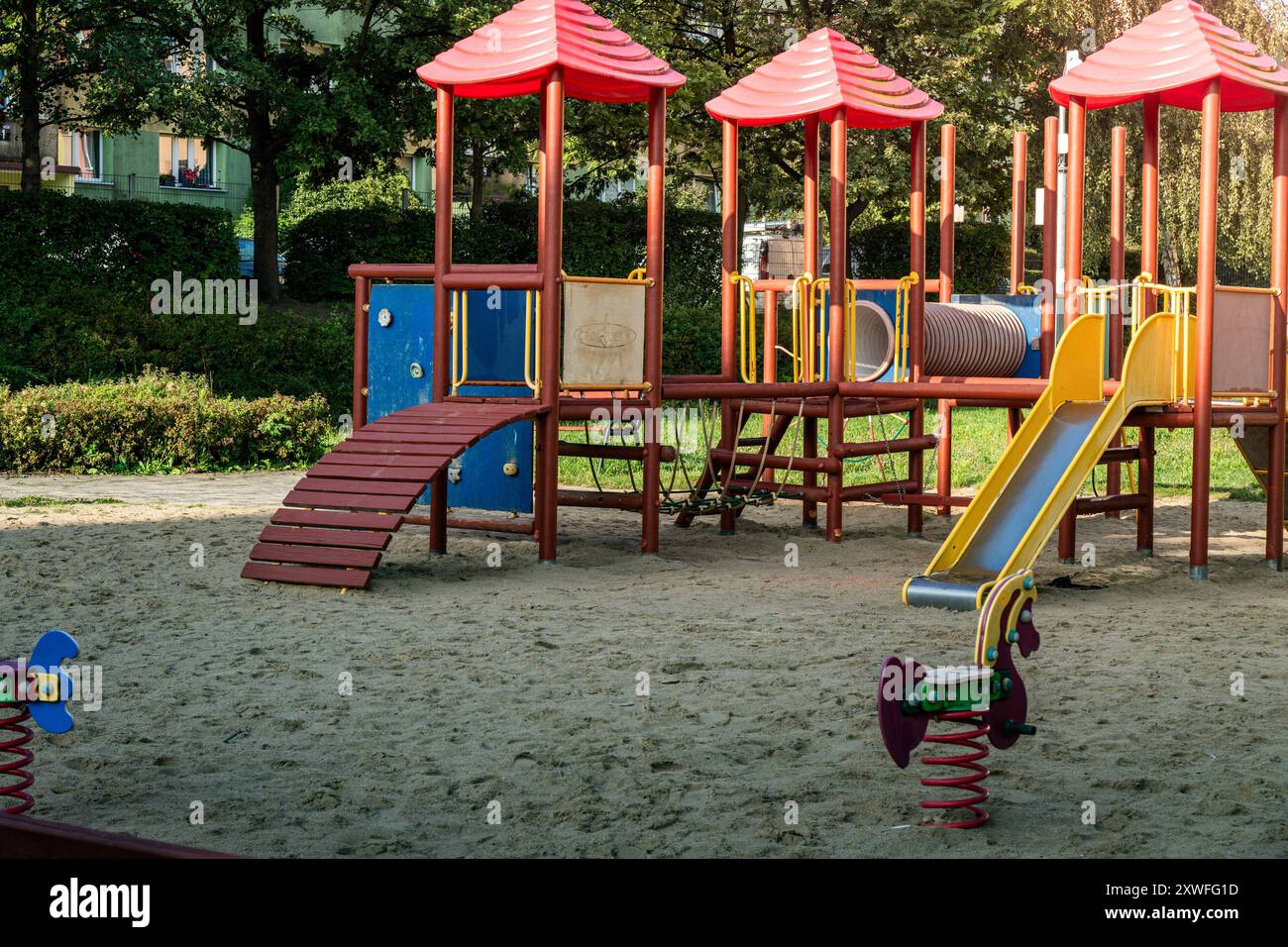 Playground structures with slides and climbing features in a sunny park ...