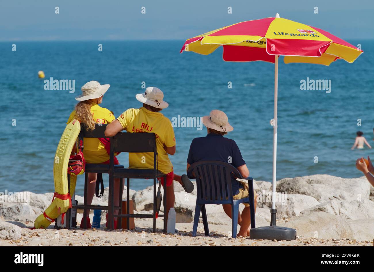 RNLI Lifeguards Sitting Underneath An Umbrella On Duty At Avon Beach ...
