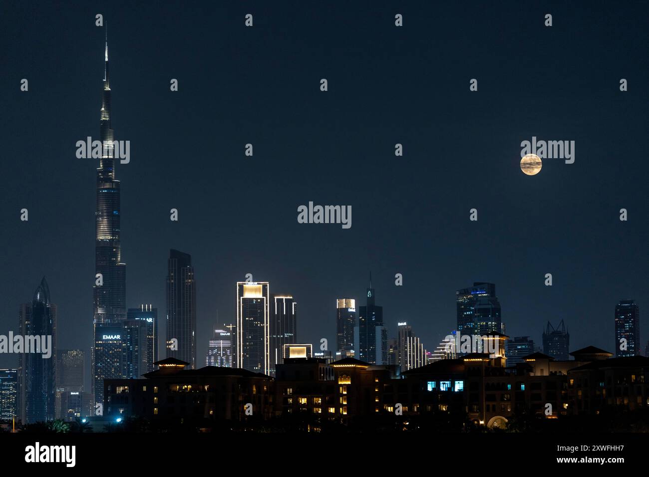 The full moon rises over the city skyline with world's tallest tower ...