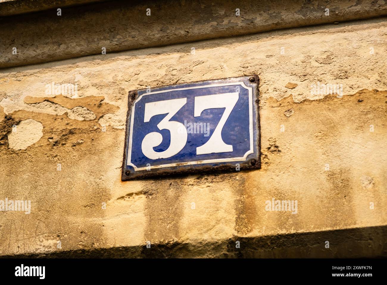Vintage Weathered House Number 37 Plaque on Rustic Wall Stock Photo - Alamy