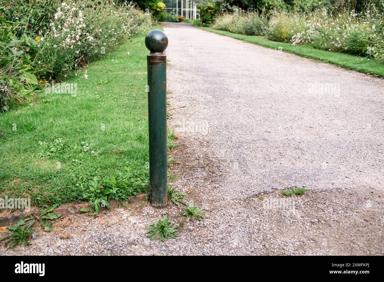 Green Metal Bollard on a Gravel Path in a Lush Garden Setting Stock ...