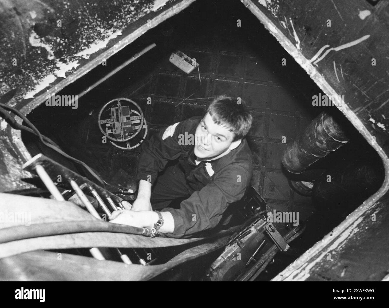 A SAILOR COMES THROUGH THE HATCH AMONGST THE HOSES USED TO FIGHT THE ...