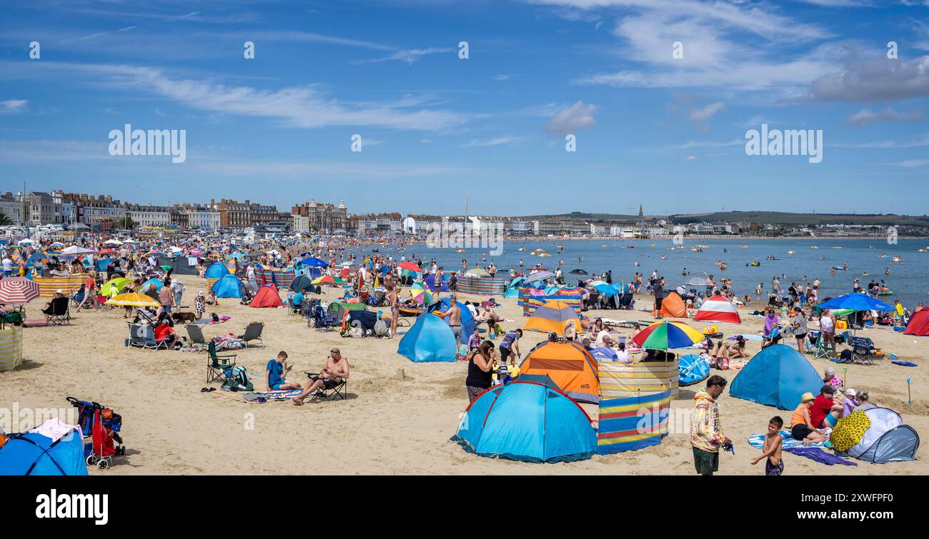Panorama of a crowded Weymouth beach on a hot summers day in Weymouth ...