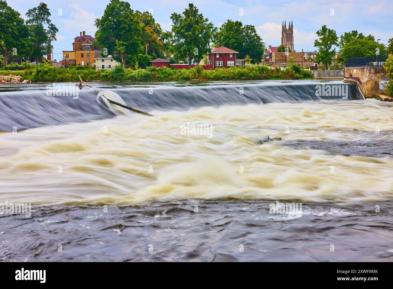 Flowing River Over Weir with Small Town Backdrop Eye-Level Perspective ...