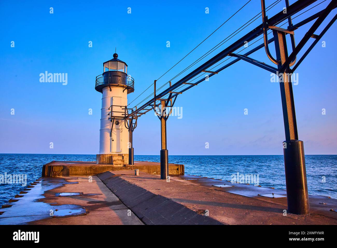 White Lighthouse on Pier at Golden Hour with Industrial Walkway ...