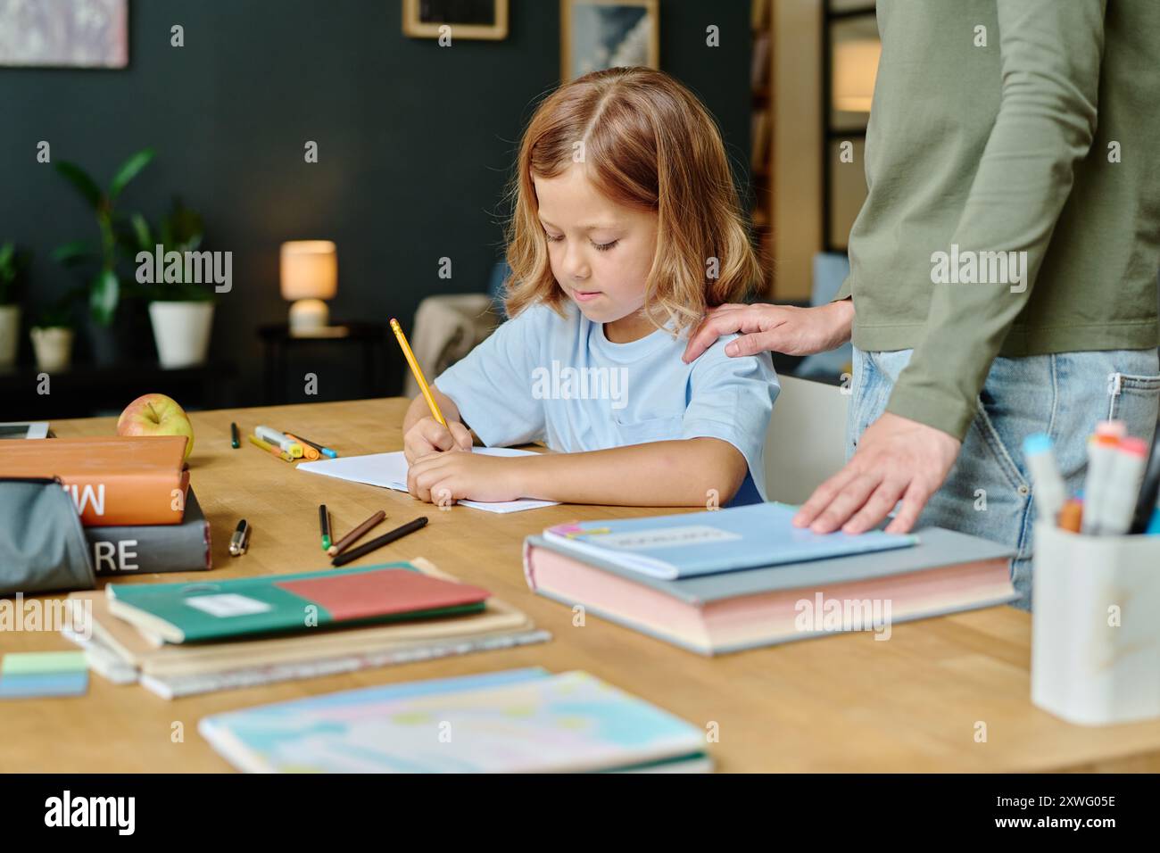 Little girl doing sums while her mother supporting her Stock Photo - Alamy