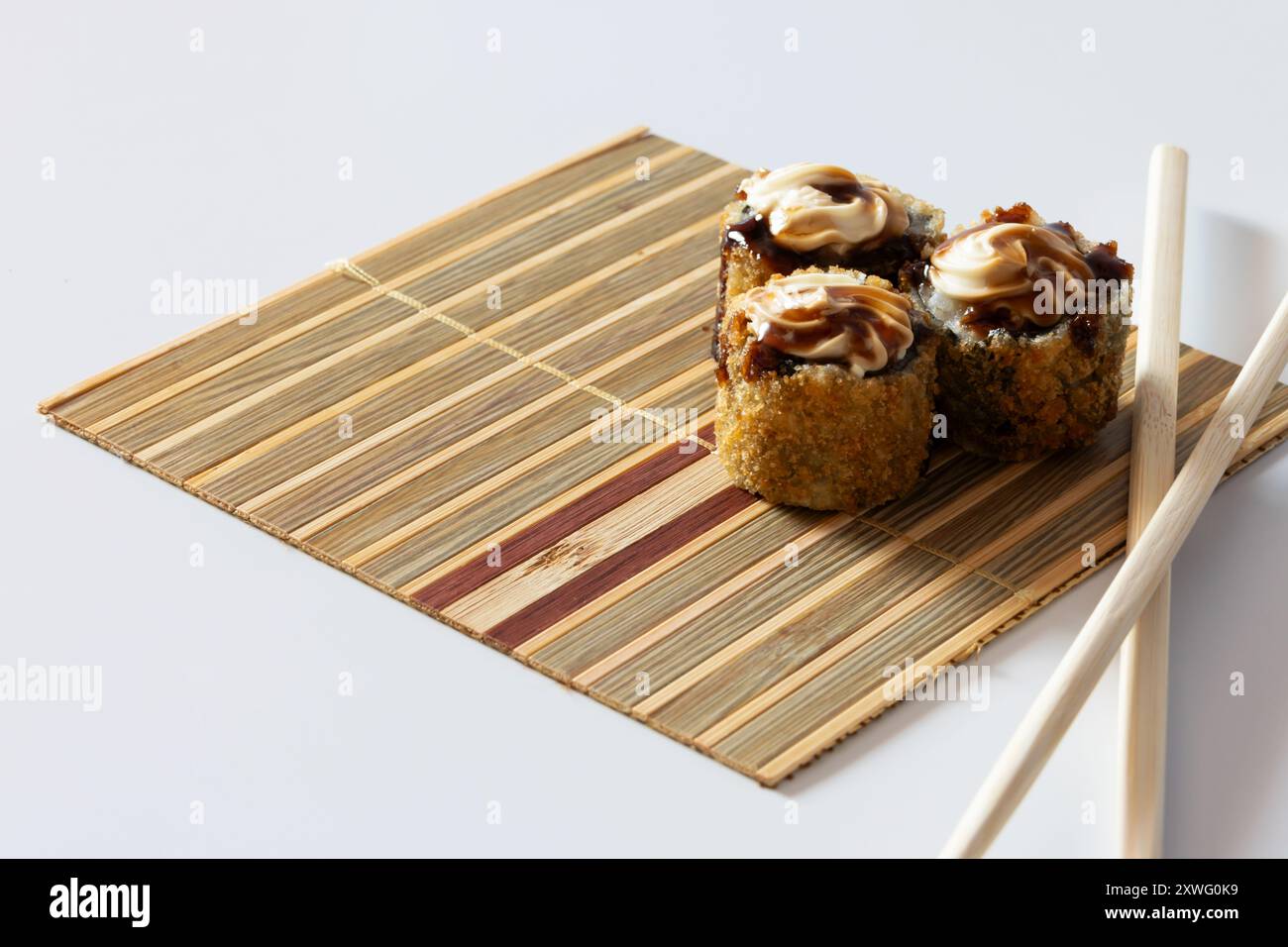 Three hot rolls topped with cream cheese and tare sauce on top of a ...