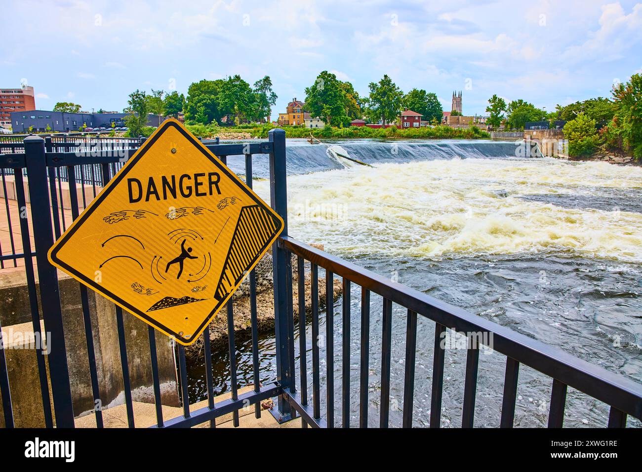 Danger Sign and Rushing Water with Community in Background Eye-Level ...