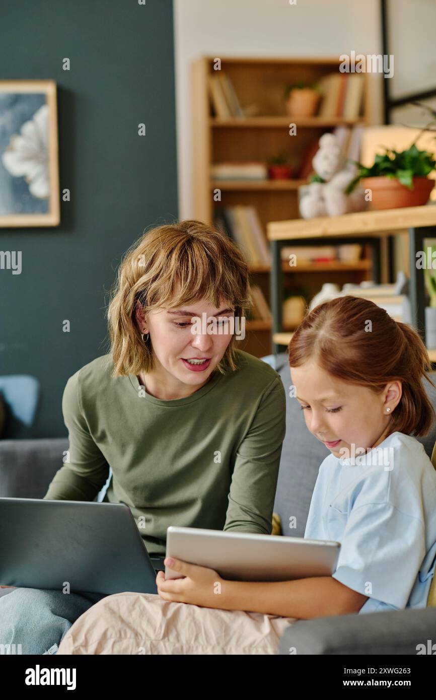 Elementary school student showing excellent marks to her mom who ...