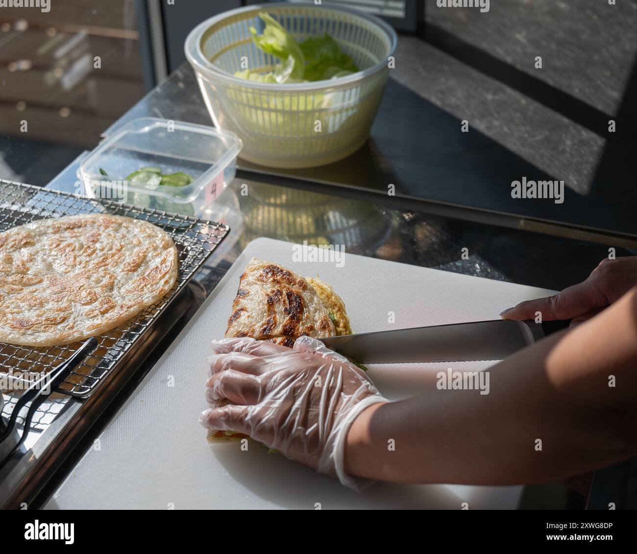 The cook cuts the flatbread with salmon. Quesadilla Stock Photo - Alamy