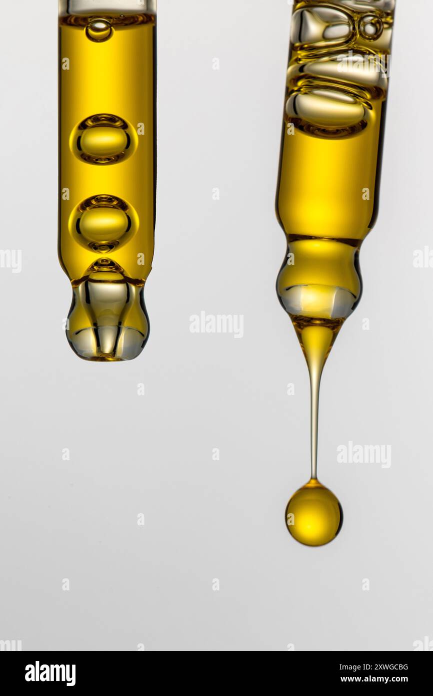 Dripping cosmetic serum from pipettes on white background Stock Photo ...