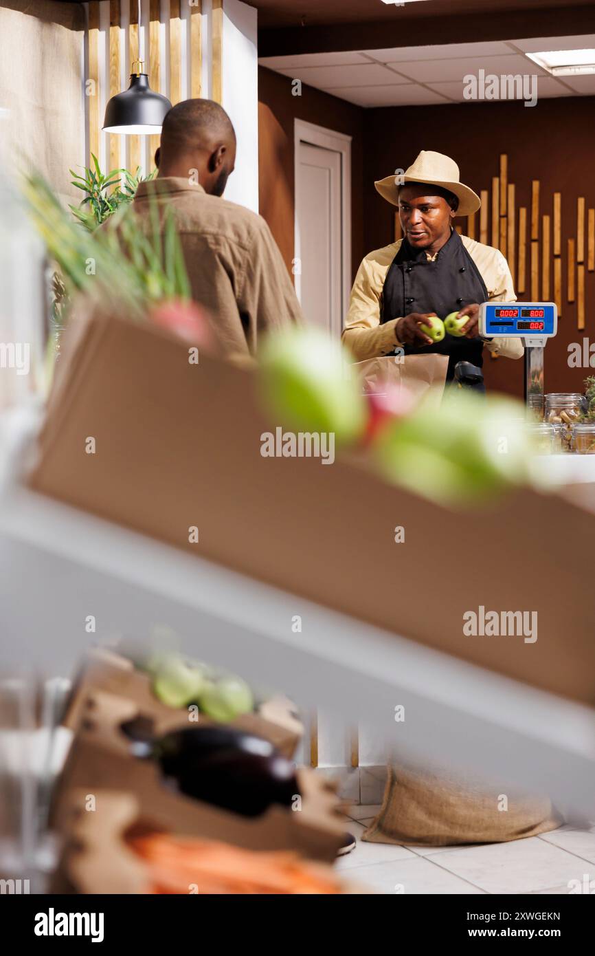 African American shopkeeper being of service to the customer at the ...